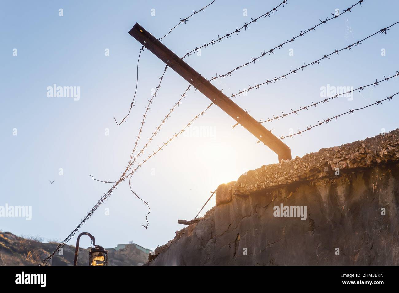 Close-up view prison or border concrete wethered fence broken old rusty ...
