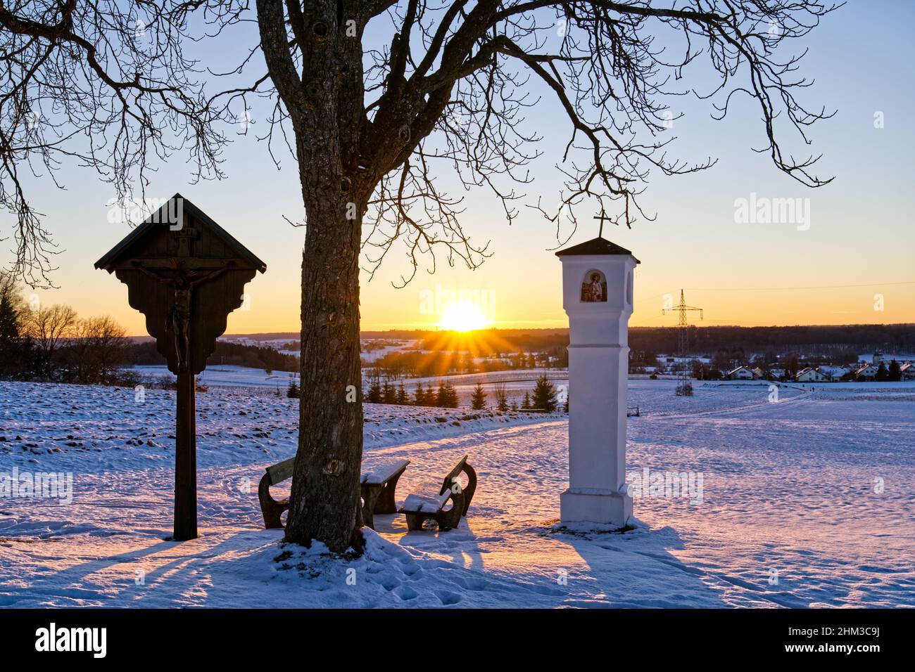 View of the winter sunset over a small church tower and wooden Christ ...