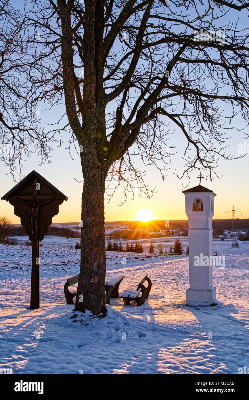 View of the winter sunset over a small church tower and wooden Christ ...