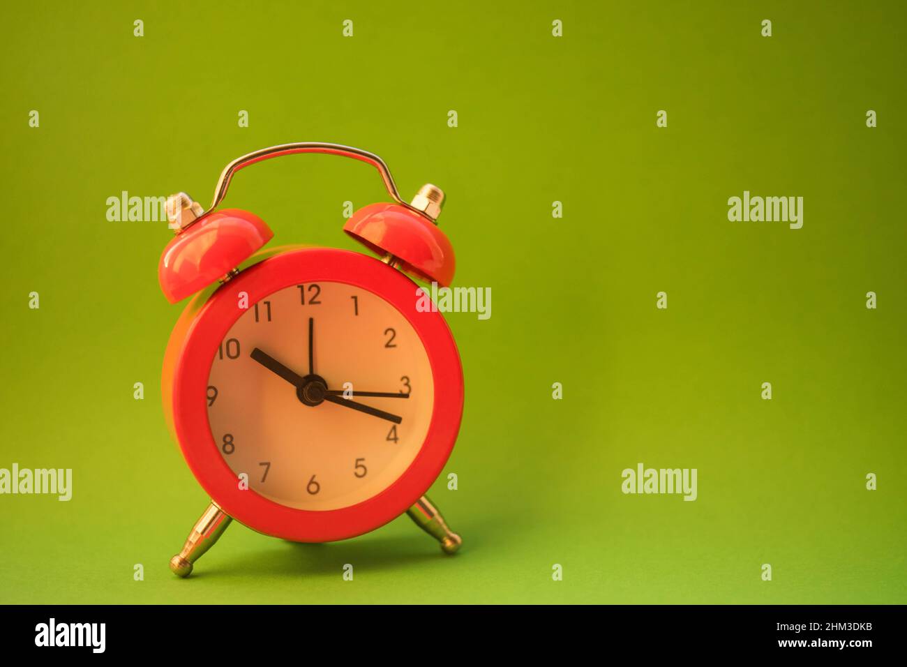 new red round clock on green table, side view, copy space Stock Photo ...