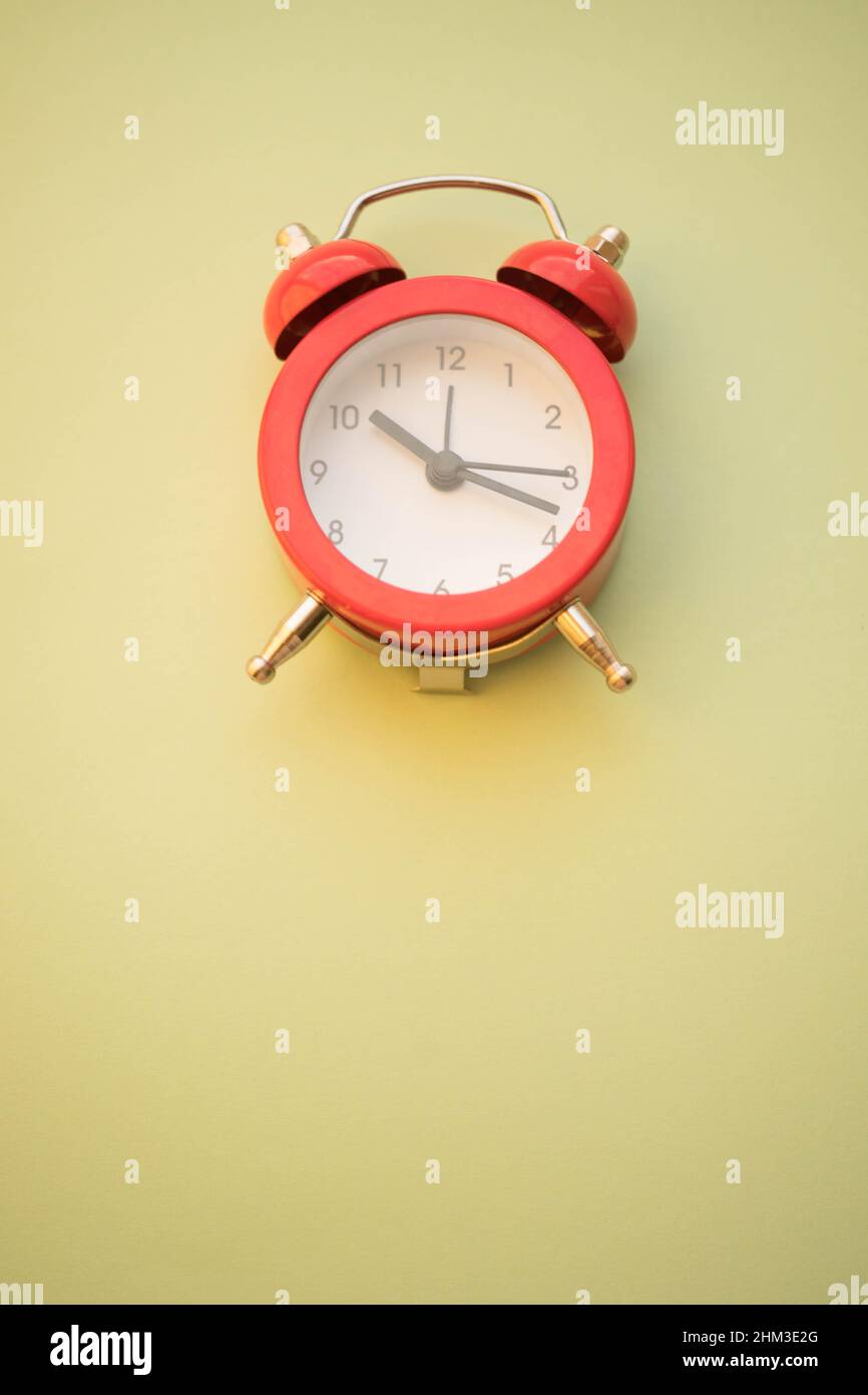 new red round clock on pale green table, copy space Stock Photo - Alamy