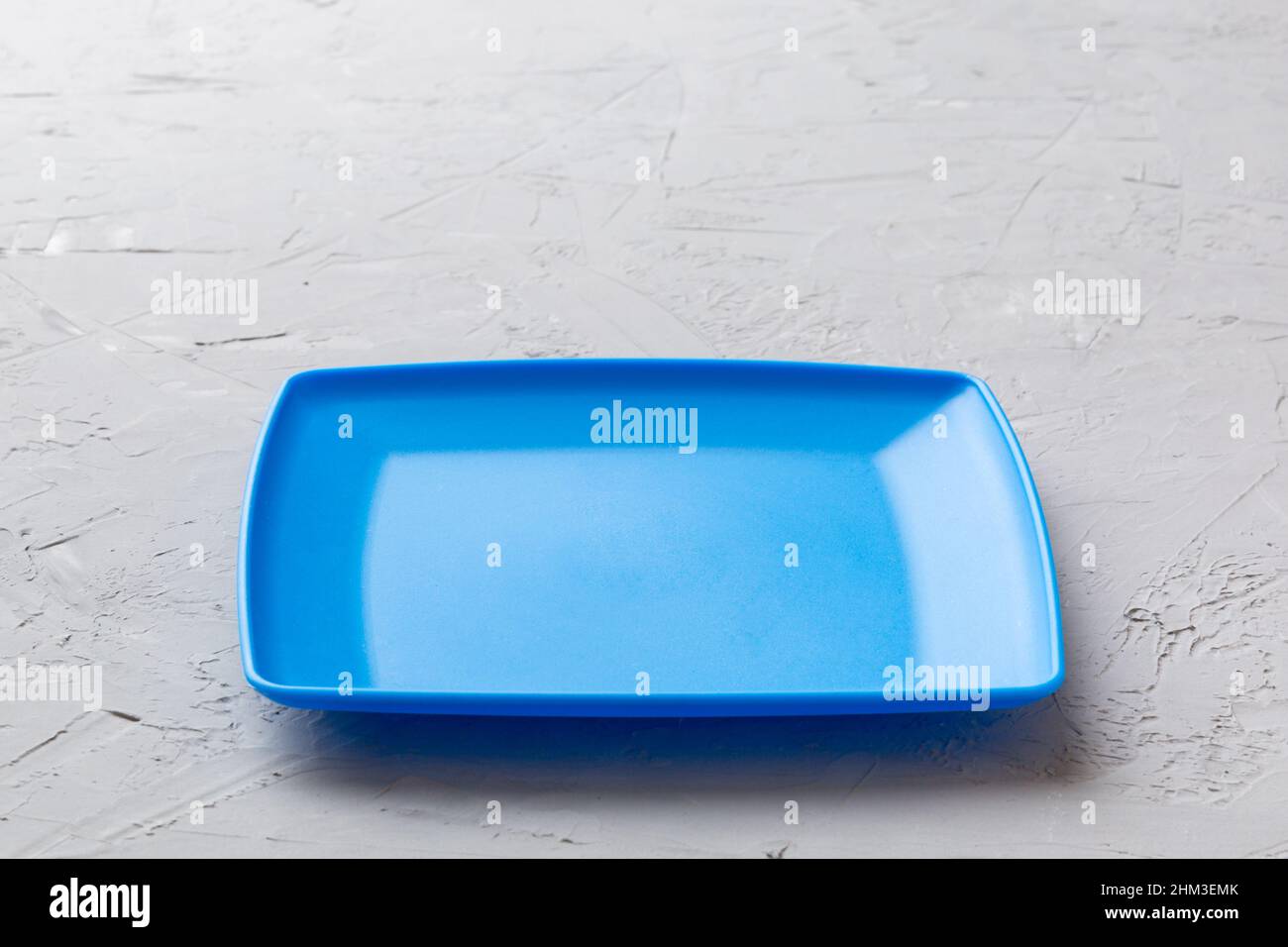 Perspective view of empty square plate on cement background. Empty ...