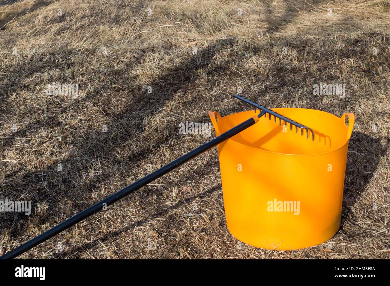 Orange bucket and black rake, gardening equipment and tool Stock Photo ...