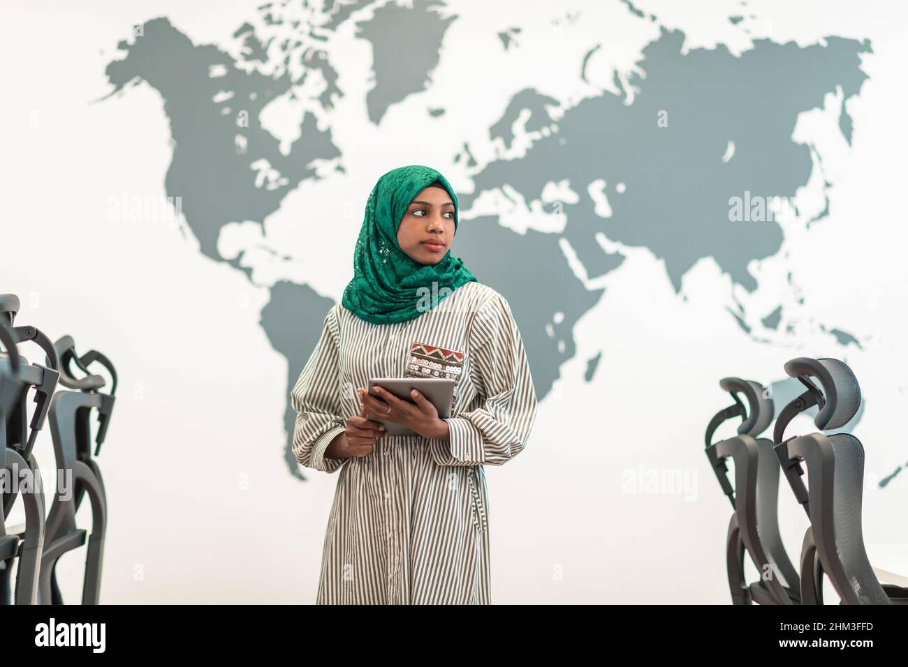 Portrait of muslim female software developer with green hijab holding ...