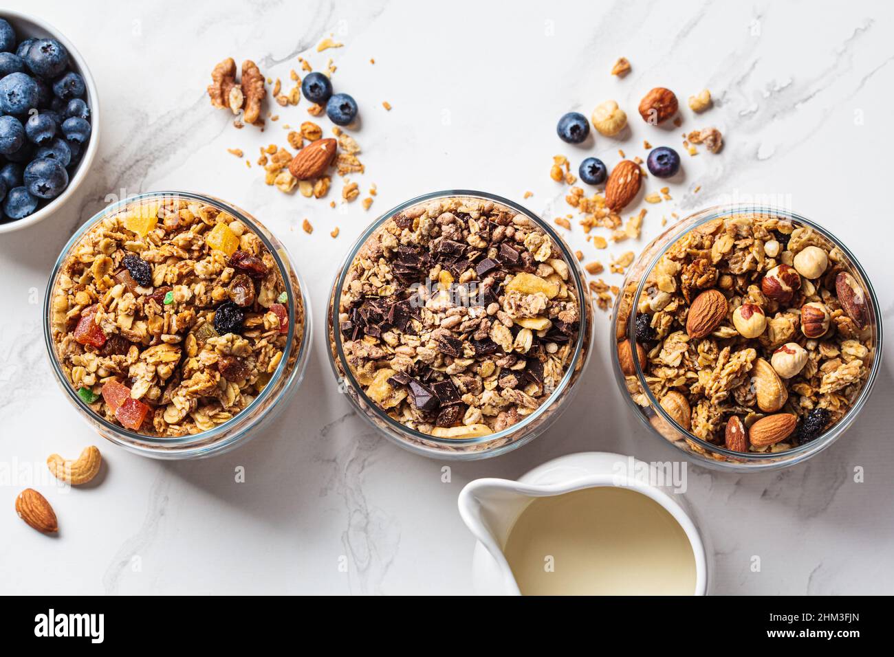Different types of homemade granola (fruit, nut and chocolate) in jars ...
