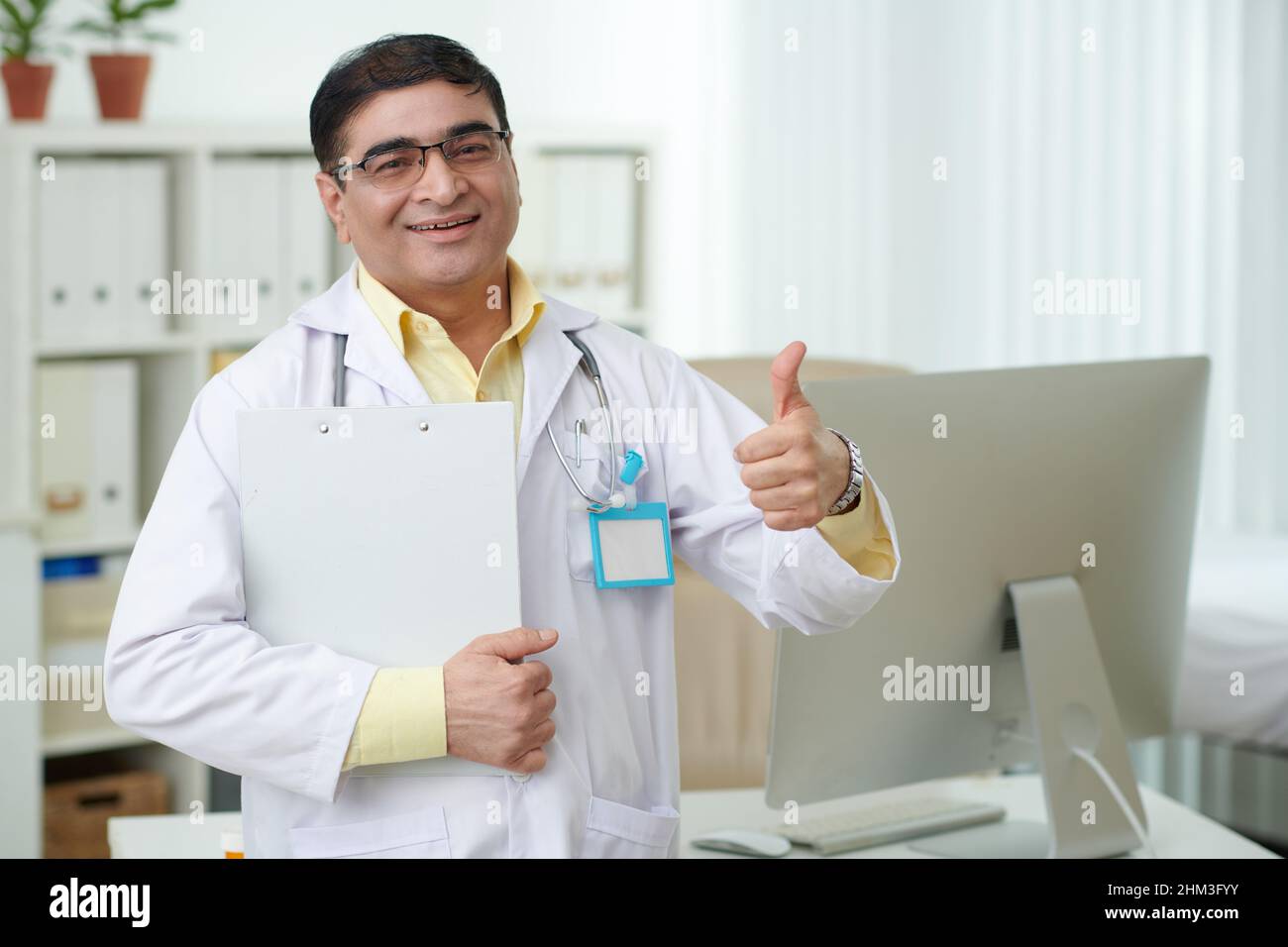Happy smiling general practitioner with clipboard showing thumbs-up ...