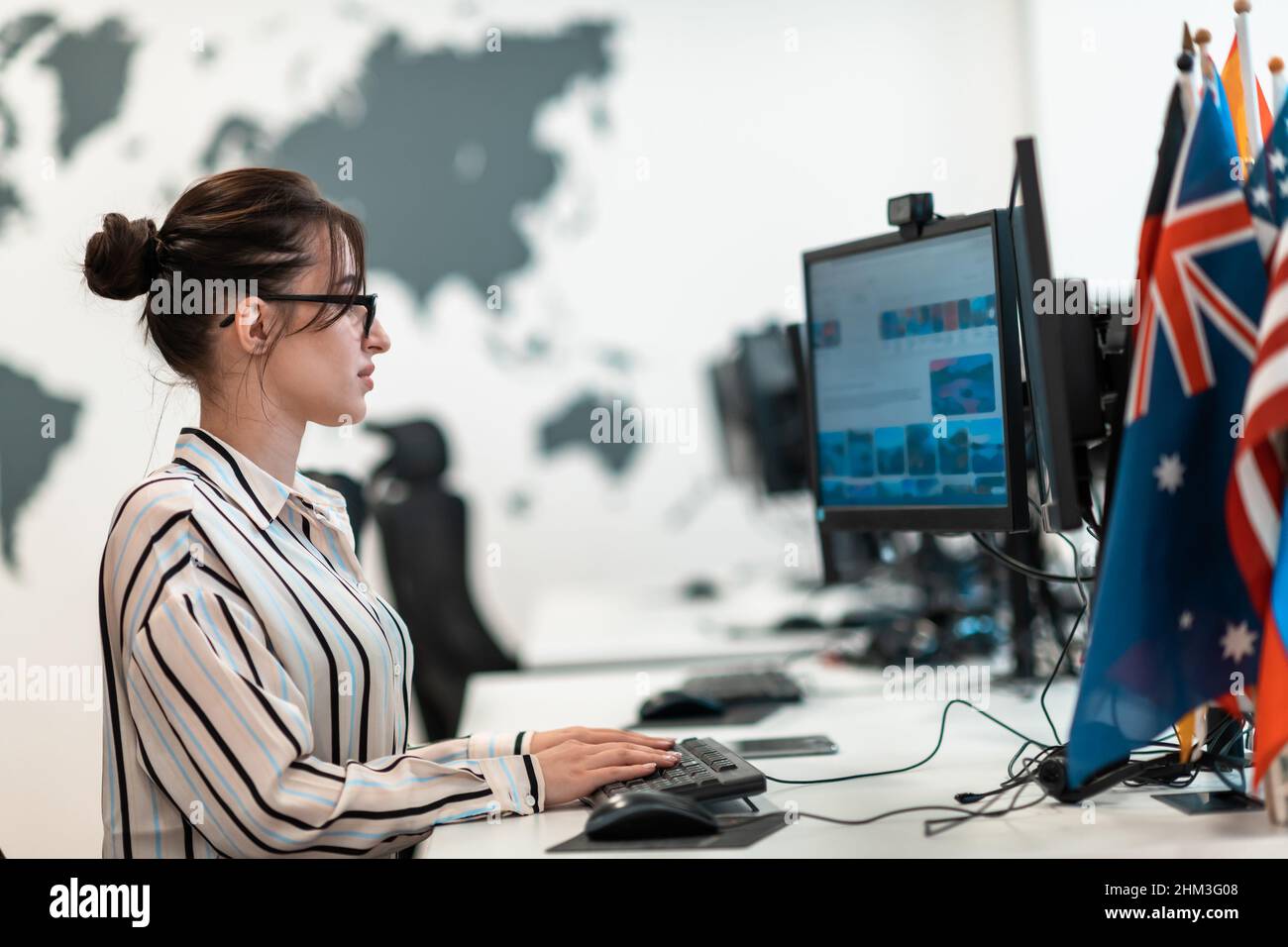 Casual business woman working on desktop computer in modern open plan ...