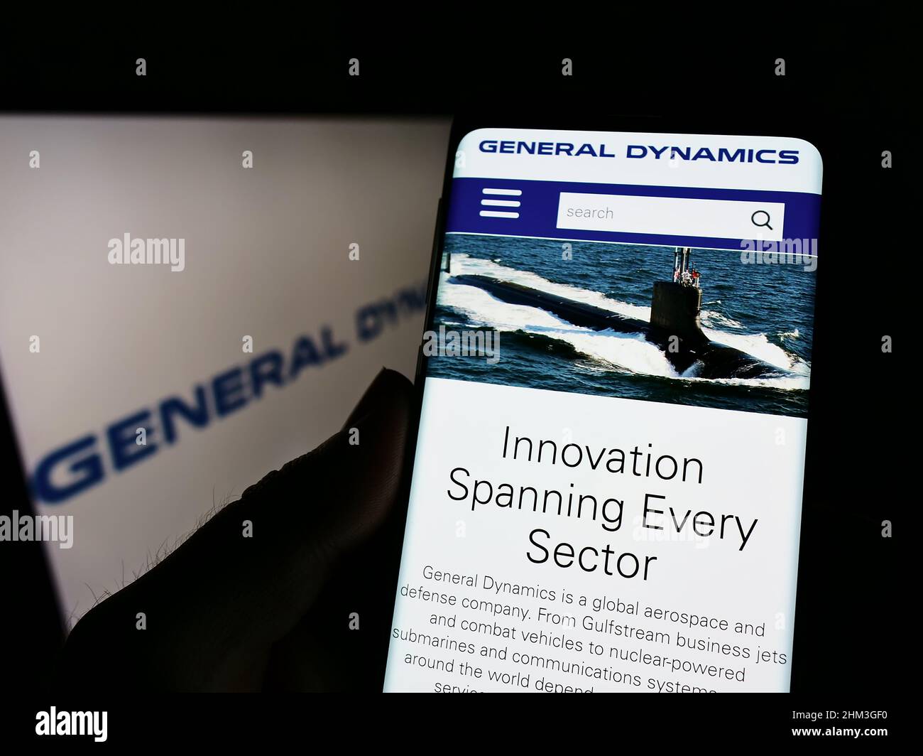 Person holding cellphone with website of US company General Dynamics ...