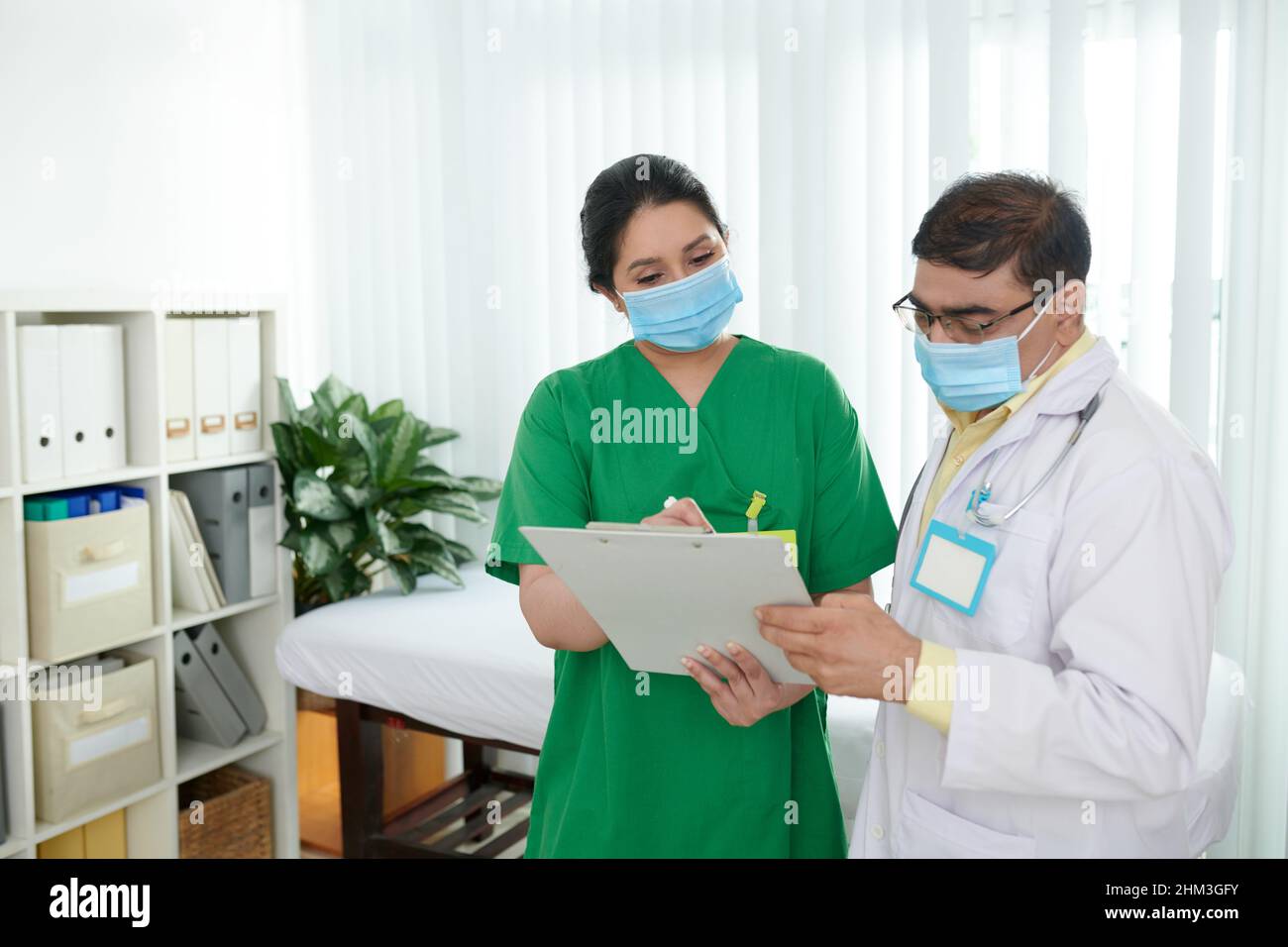 Medical nurse giving physician document to sign after examination of ...