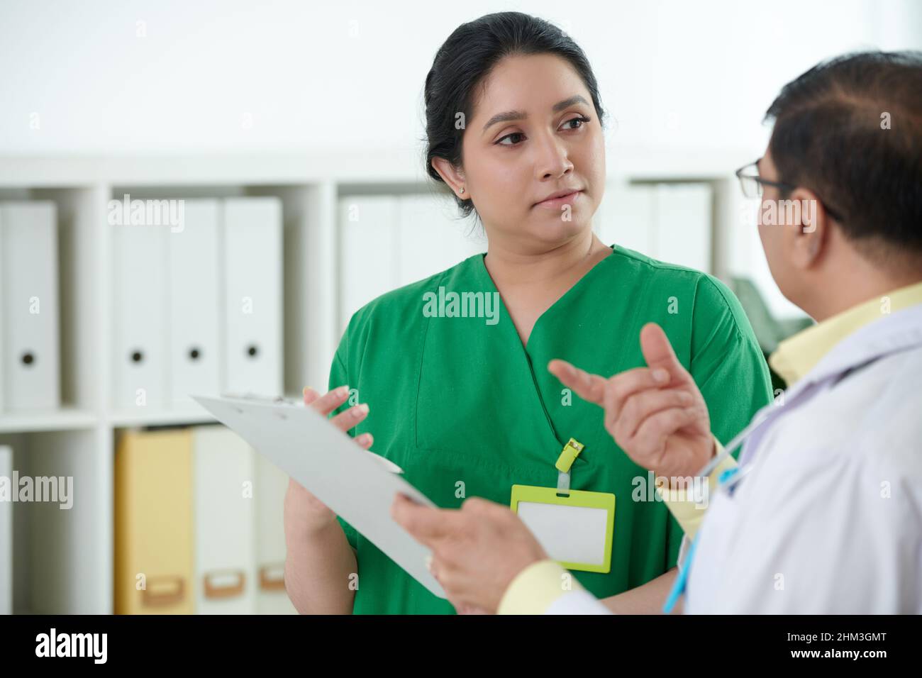 Female discussing difficult case with head physician and showing ...