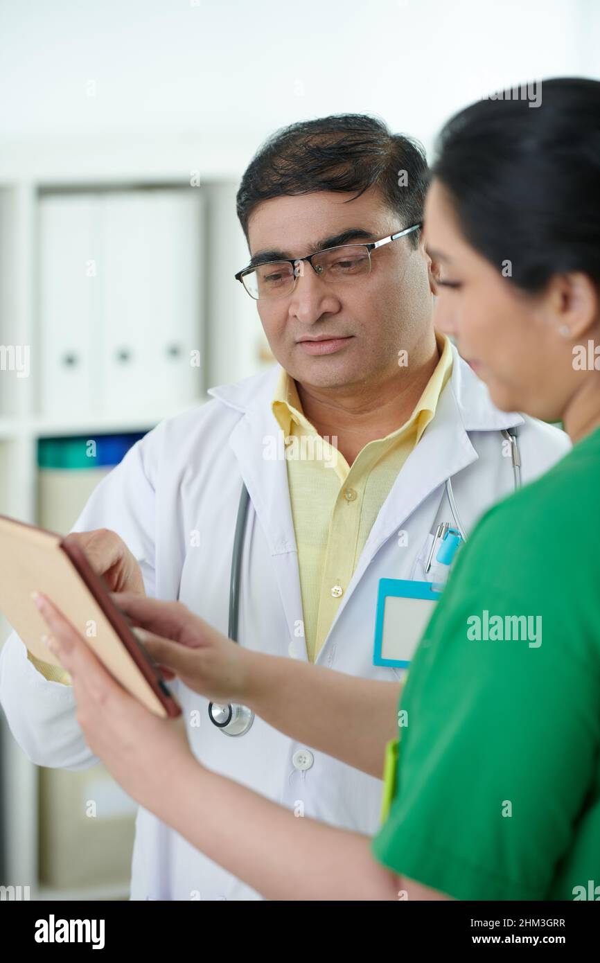 Medical nurse showing tablet computer with medical tests results of ...