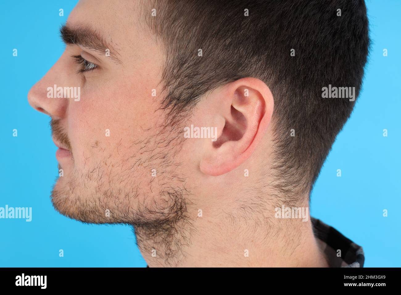 Side view photo of young man head on blue background Stock Photo - Alamy