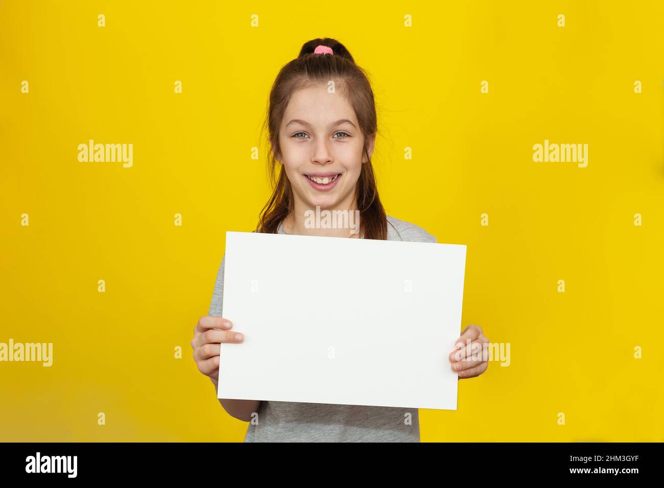 Girl holding white sheet. Cute little girl with white sheet of paper on ...