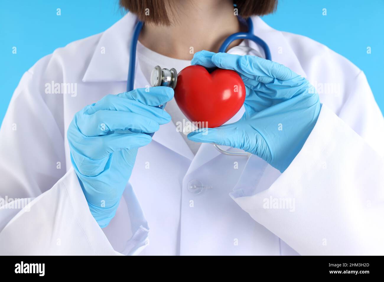 Female trainee doctor with heart on blue background Stock Photo - Alamy