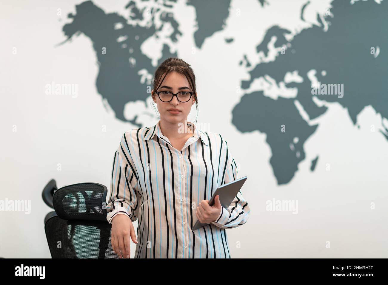 Portrait of businesswoman in casual clothes holding tablet computer at ...