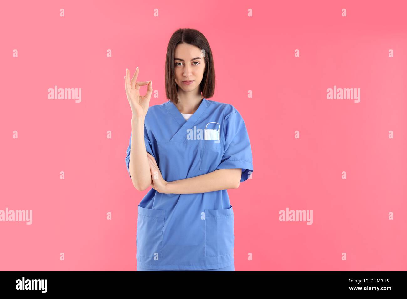 Attractive female trainee nurse on pink background Stock Photo - Alamy