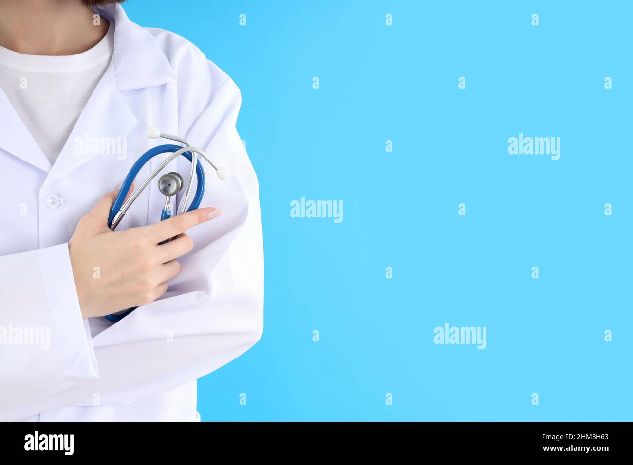 Female trainee doctor with stethoscope on blue background Stock Photo ...
