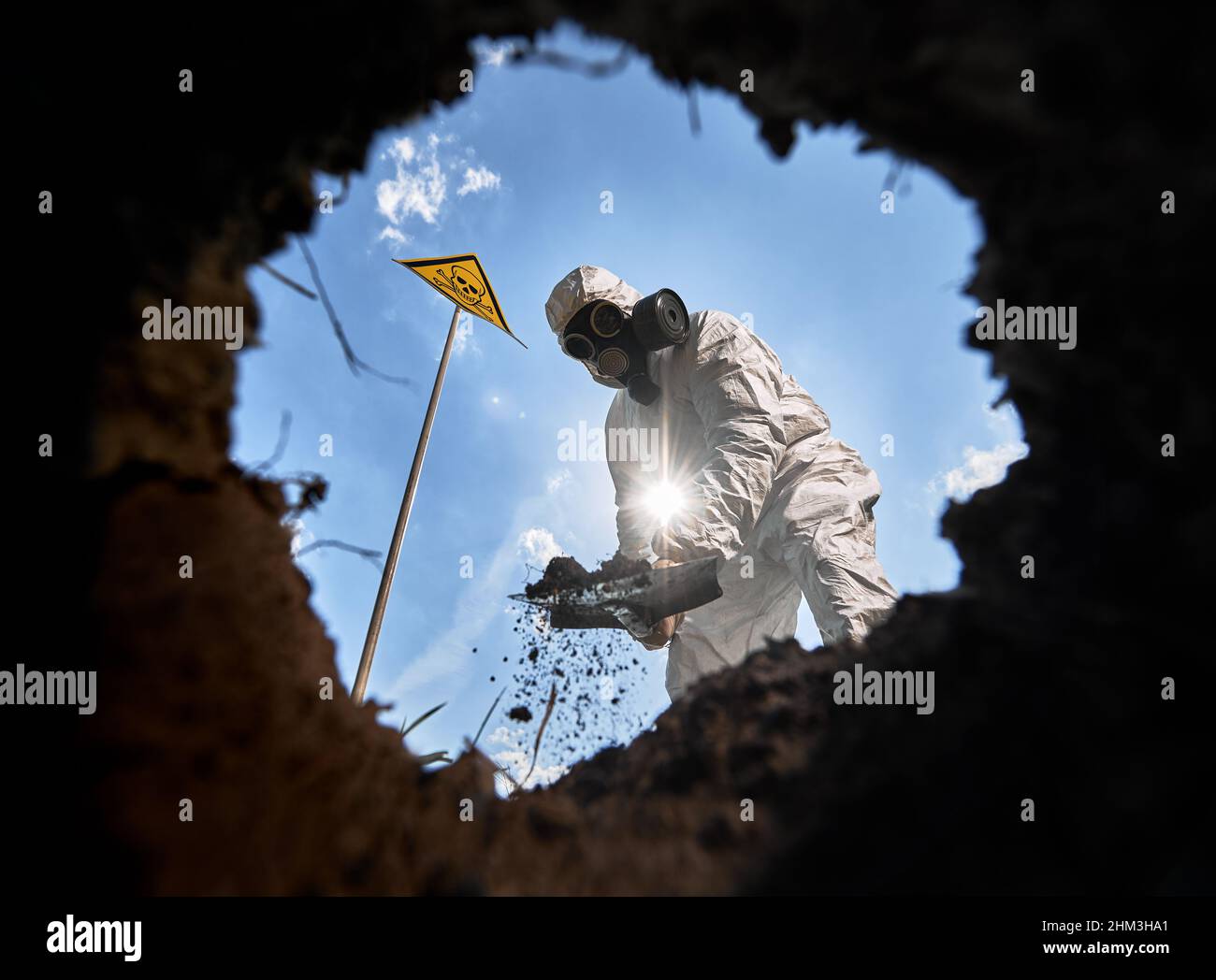 View from inside pit of ecologist digging pit by shovel, wearing gas ...