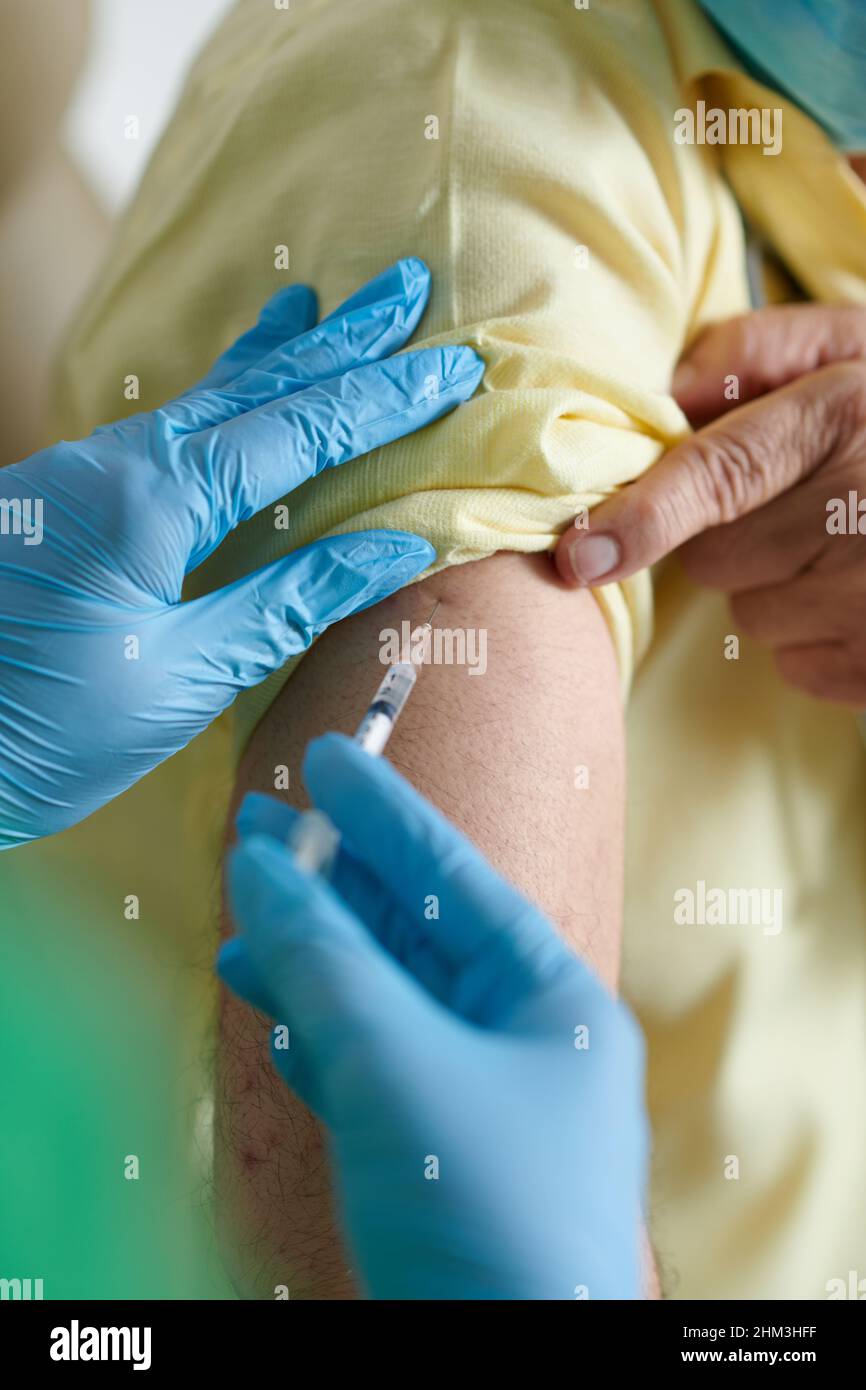 Closeup image of nurse injecting vaccine against Omicron in shoulder of ...