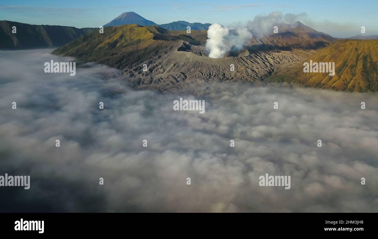 Aerial view of Mount Bromo volcano covered with thick mist at sunrise ...