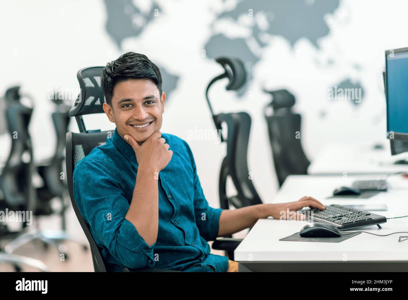 Casual business man working on desktop computer in modern open plan ...