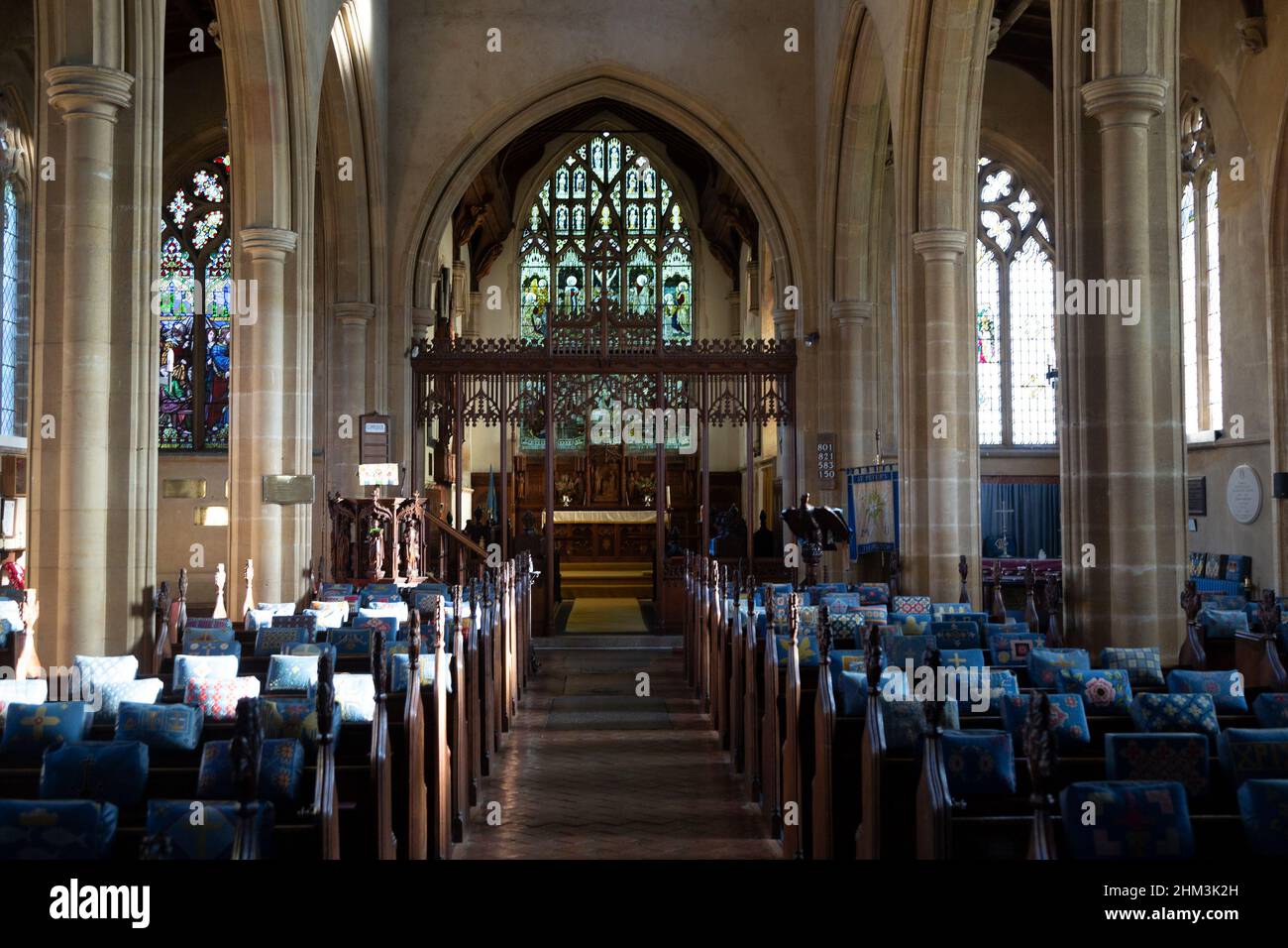 Wooden pews in nave, chancel arch, rood screen, altar and east window ...
