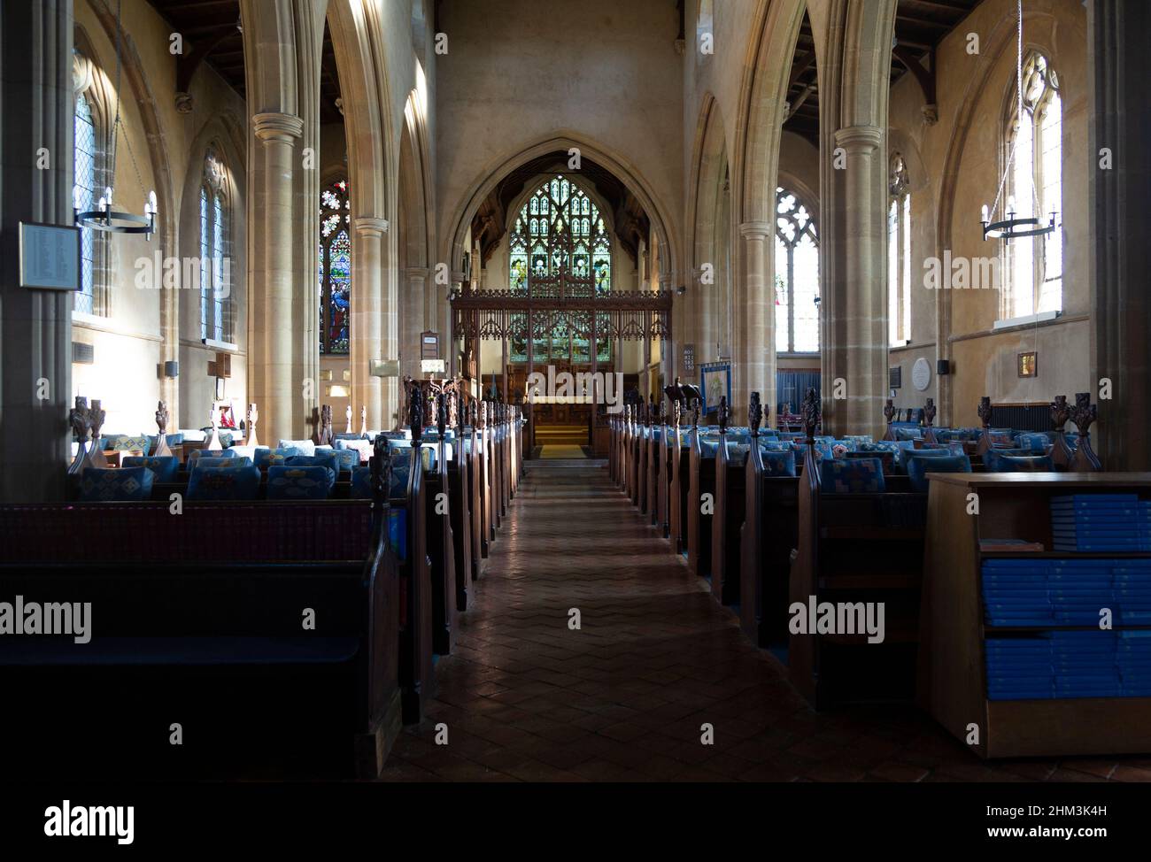Wooden pews in nave, chancel arch, rood screen, altar and east window ...
