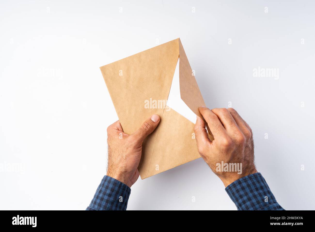 Top view of male hands hold (open) an envelope above white background ...