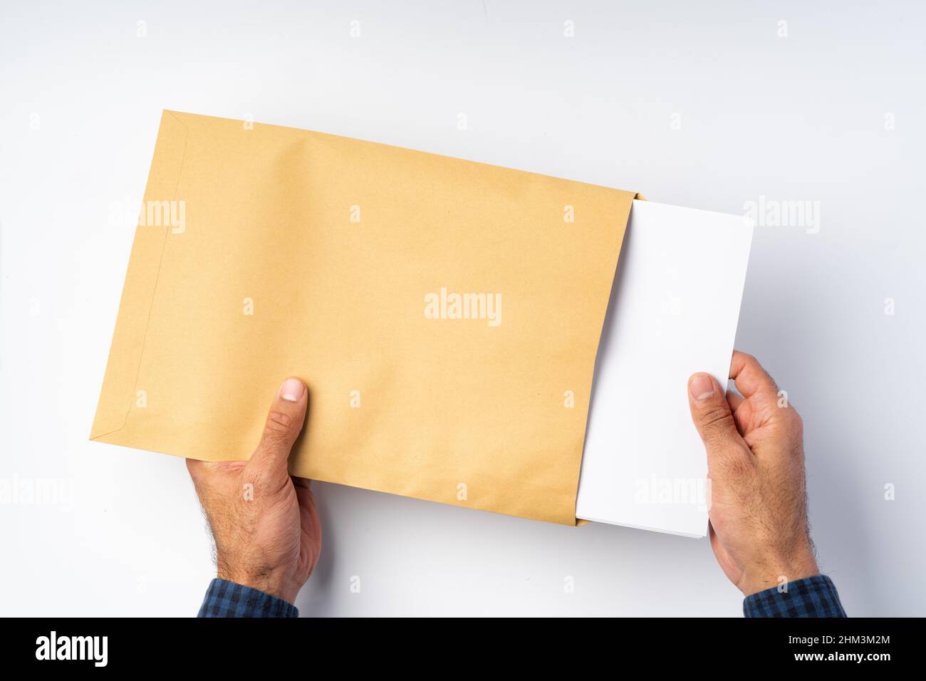 Top view of male hands hold (open) an envelope above white background ...