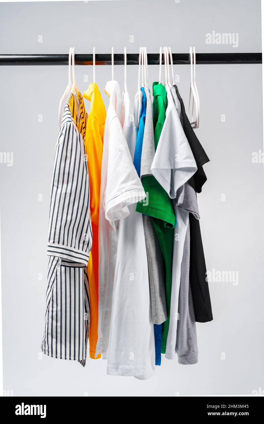 Clothes hang on clothing rack over white background Stock Photo - Alamy