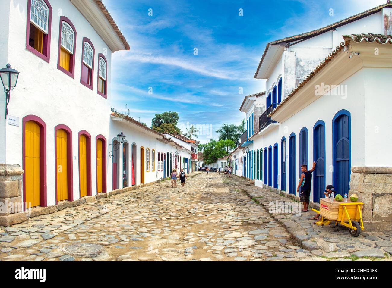 People selling coconuts in a corner of a cobblestone street and ...