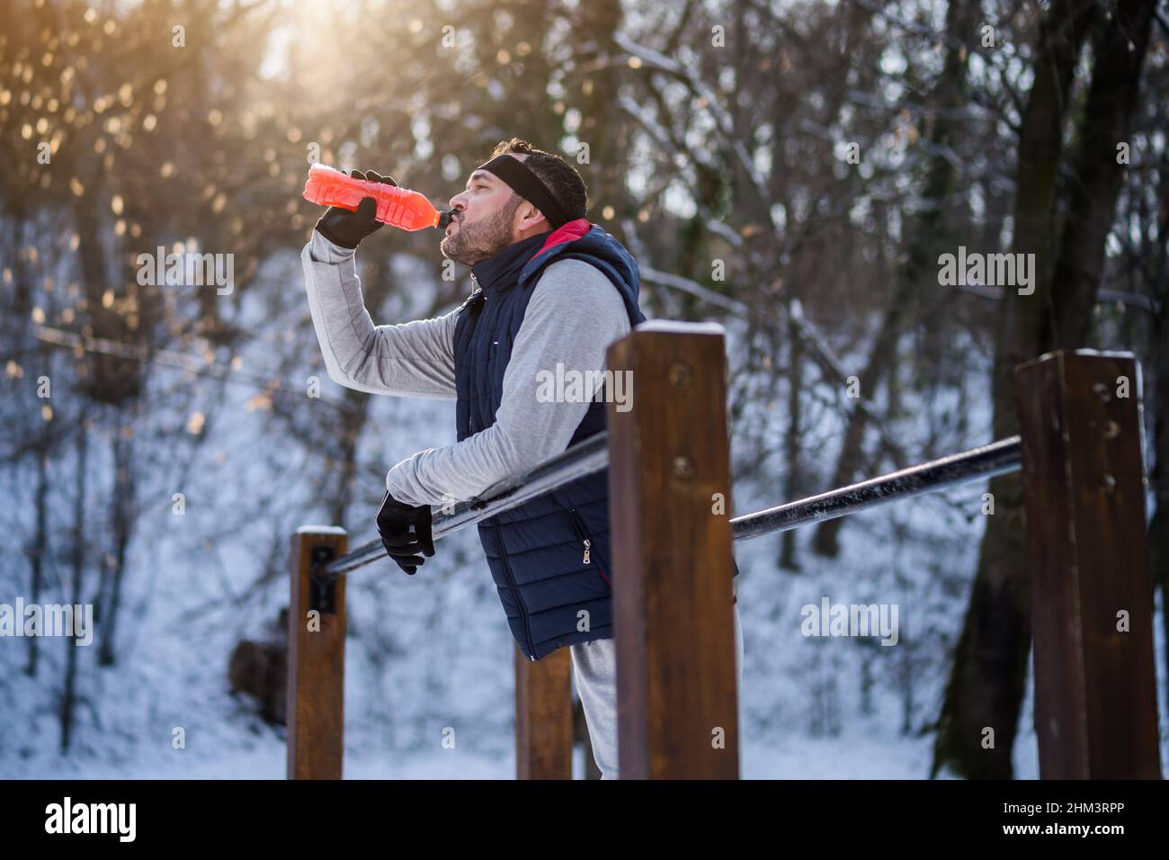 Adult man is ready for exercising on push-up bar in park in wintertime ...