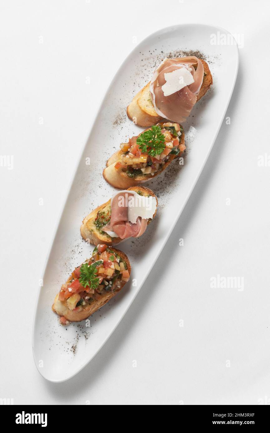 Basque Pinchos tapas with jamon serrano ham and tomato bruschetta on ...