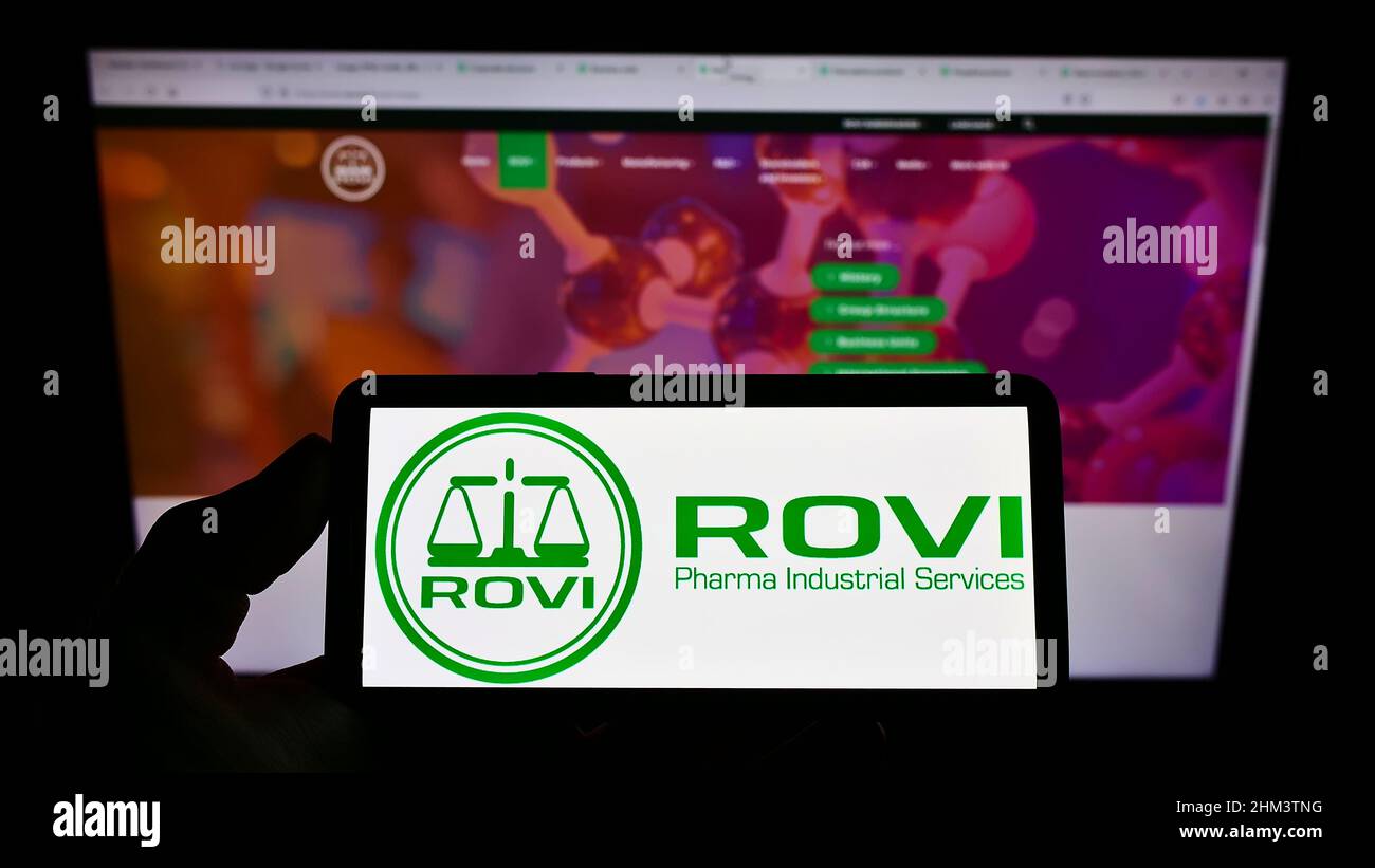 Person holding mobile phone with logo of company Laboratorios ...