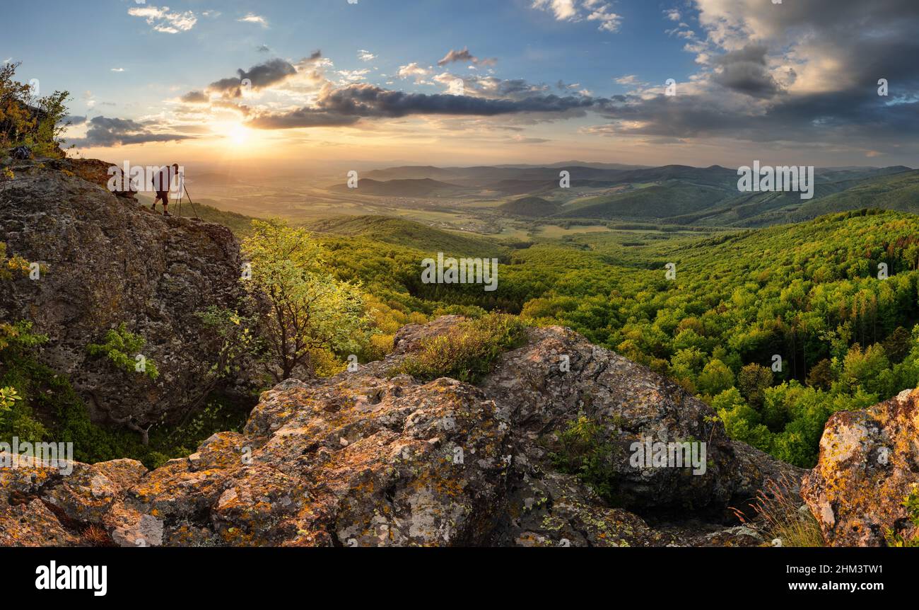 Male photographer on the mountain top with green landscape Stock Photo ...