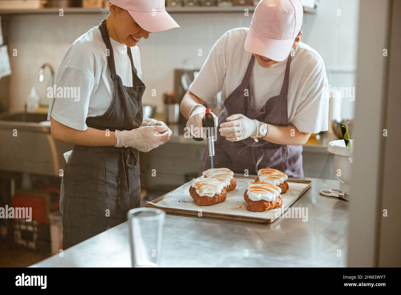 Positive confectioners decorate croissants with albumenous cream using ...