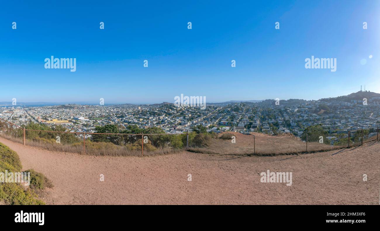 Dirt ground on top of a hill with mesh wire fence and a view of the bay ...