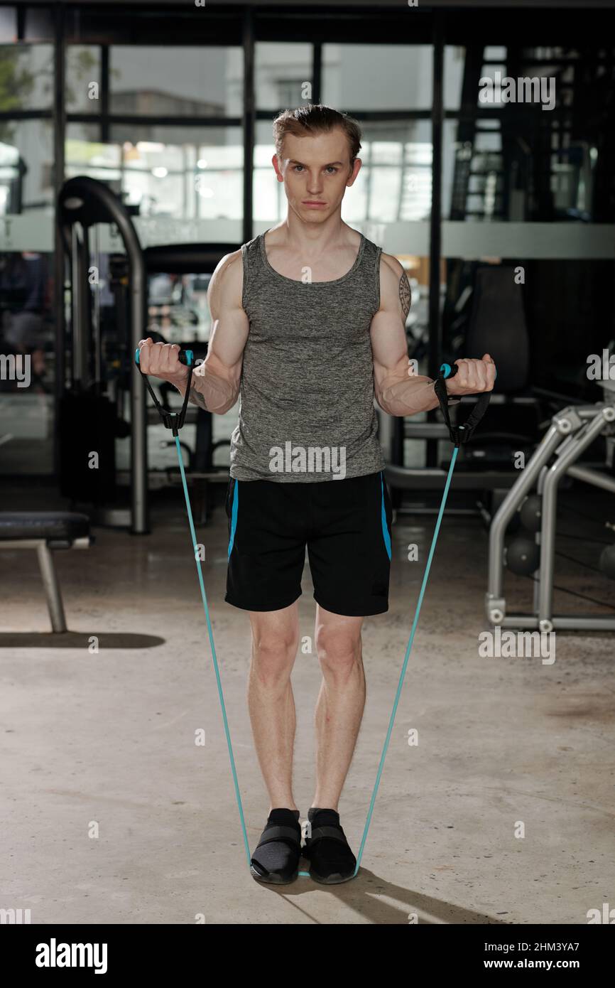 Fit young man doing exercise with resistance band to strengthen body ...