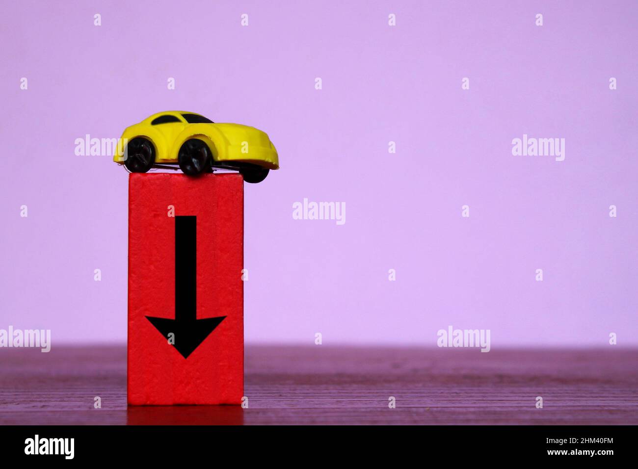 Car depreciation value, price drop concept. Toy car and red wooden ...
