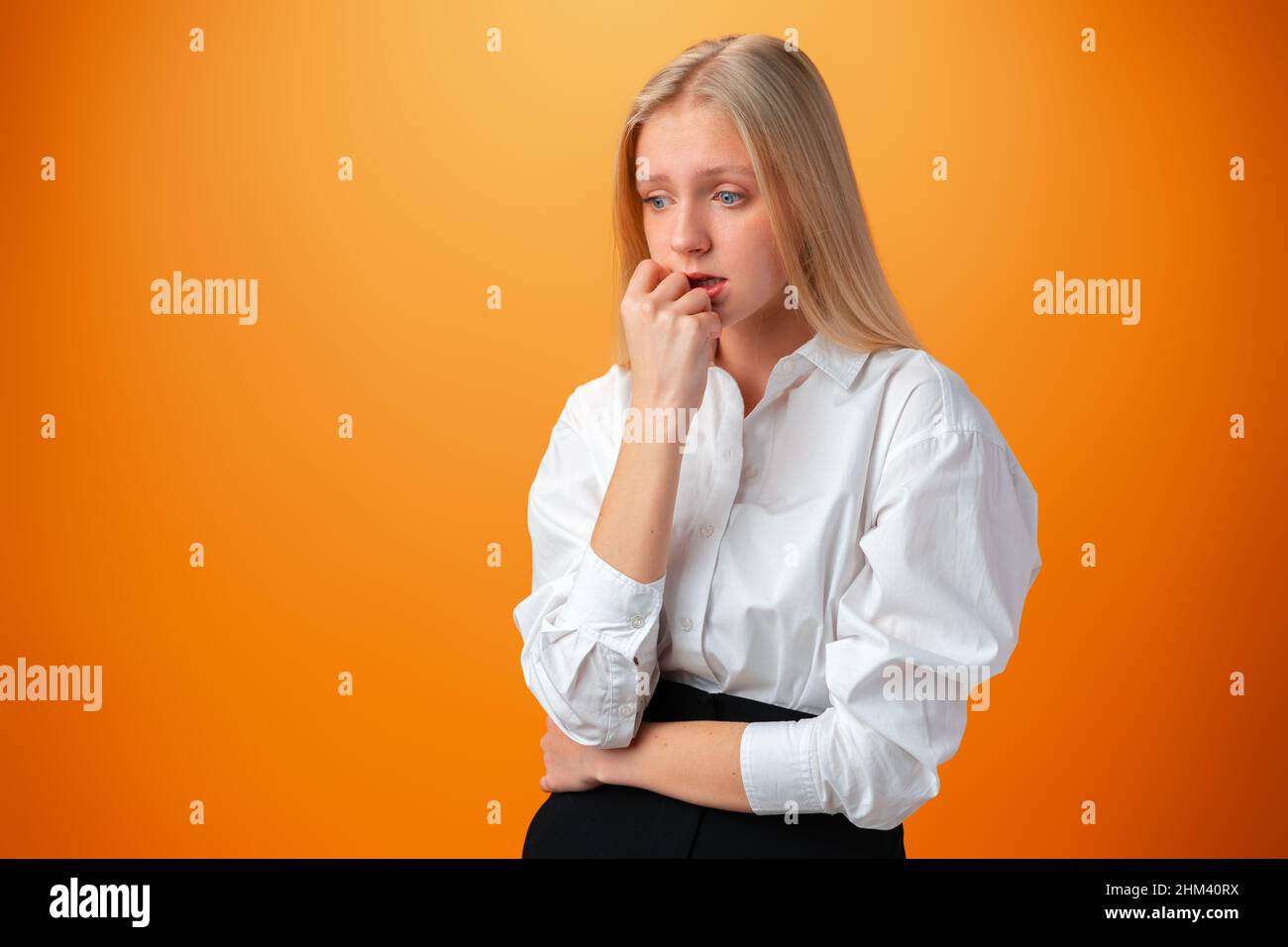 Portrait of cute thoughtful teen girl against orange background Stock ...