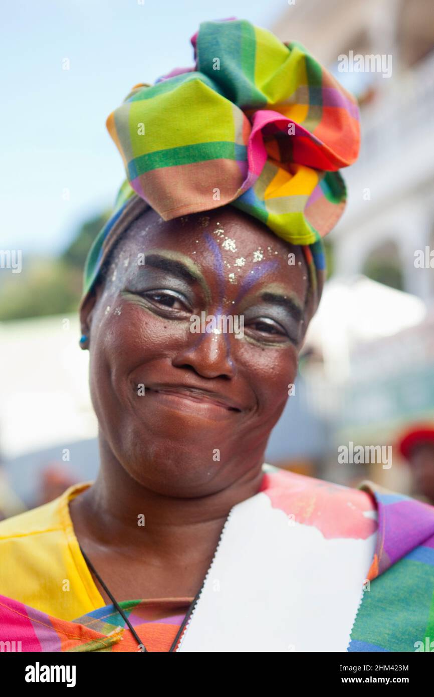 Portrait of a woman smiling and wearing a textile headdress while ...