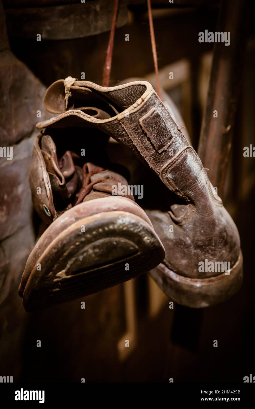 Old worn out brown leather boots hanging on a brick wall Stock Photo ...