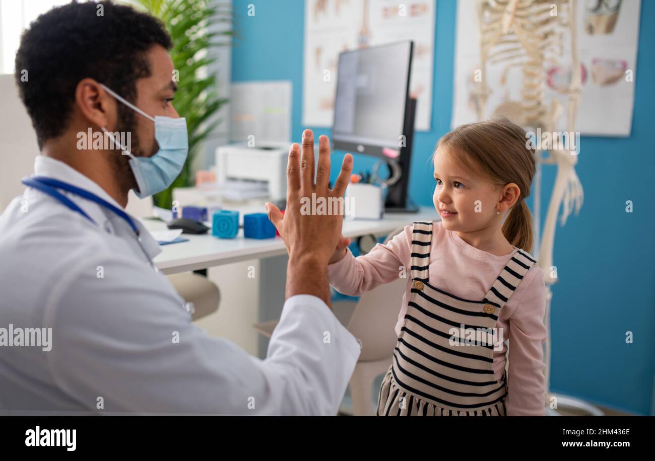 Little girl at doctor's office on, high fiving with doctor Stock Photo ...