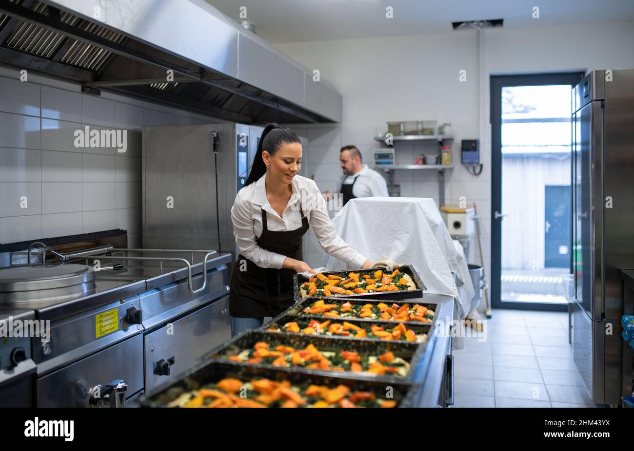 Chef and cook working on their dishes indoors in restaurant kitchen ...