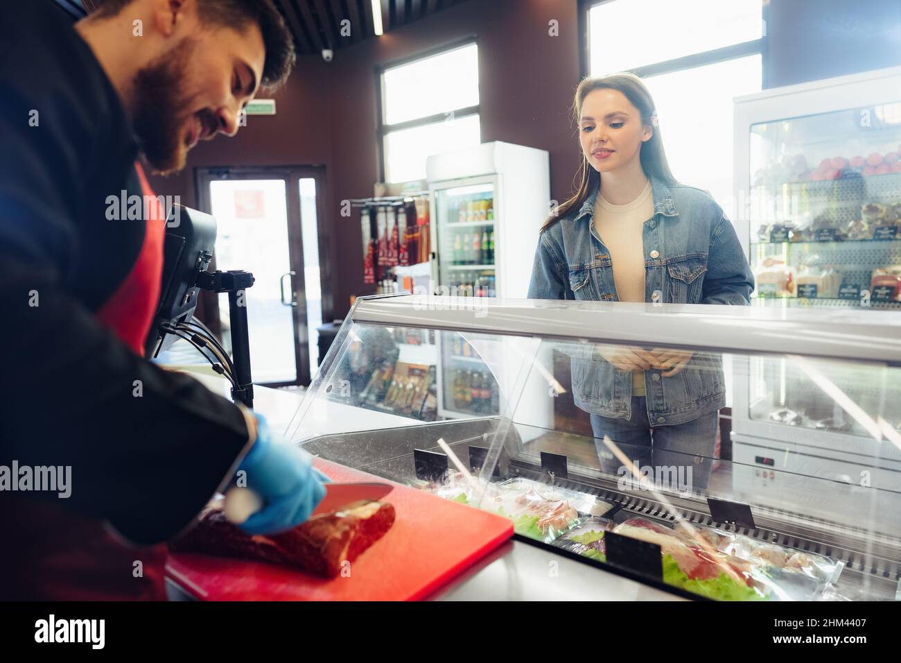 Female customer against raw meat stall section in food store Stock ...