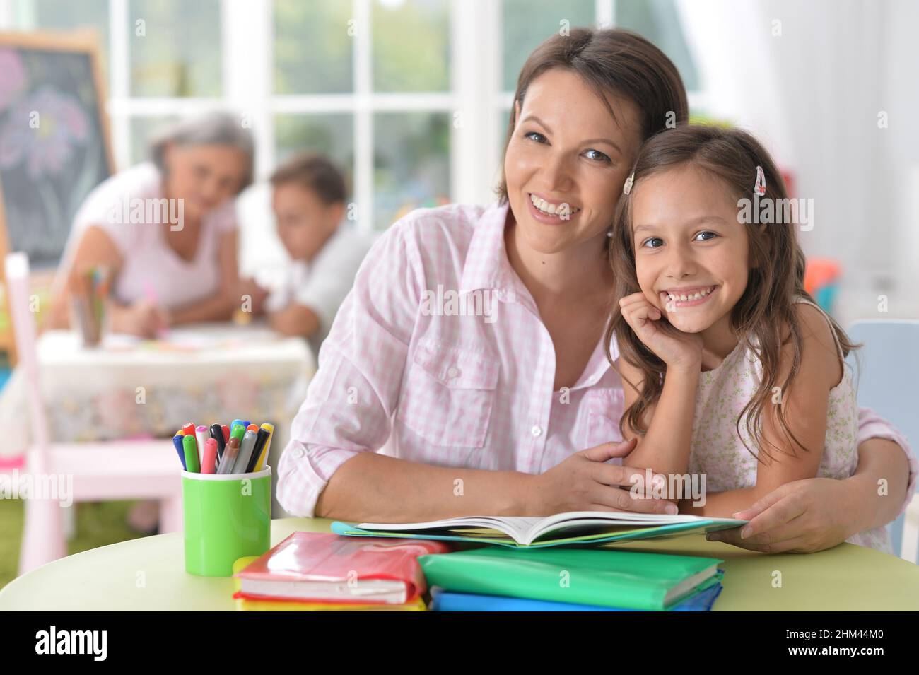 Portrait of mother and her daughter doing homework Stock Photo - Alamy