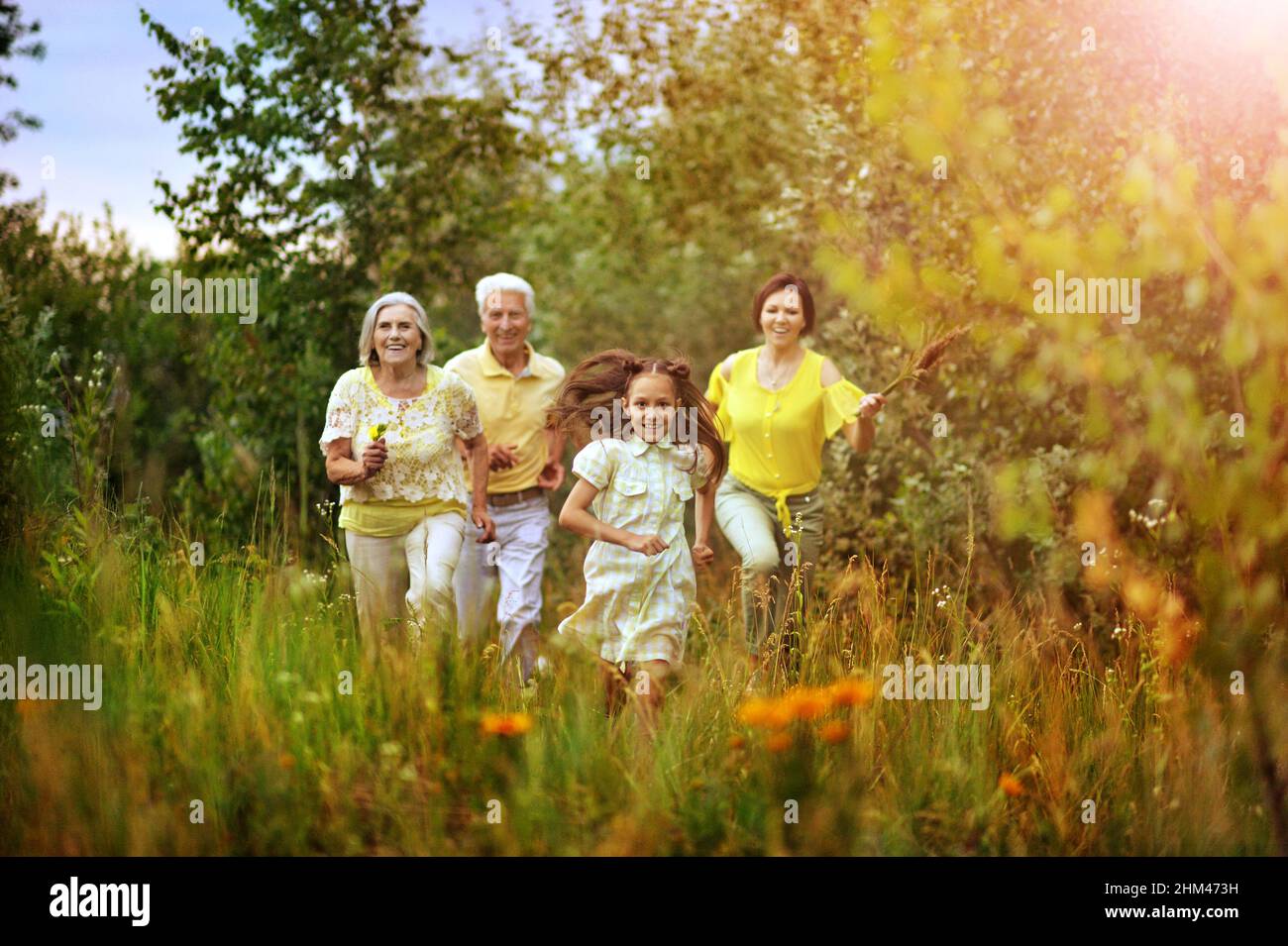 Portrait of happy family running in field Stock Photo - Alamy