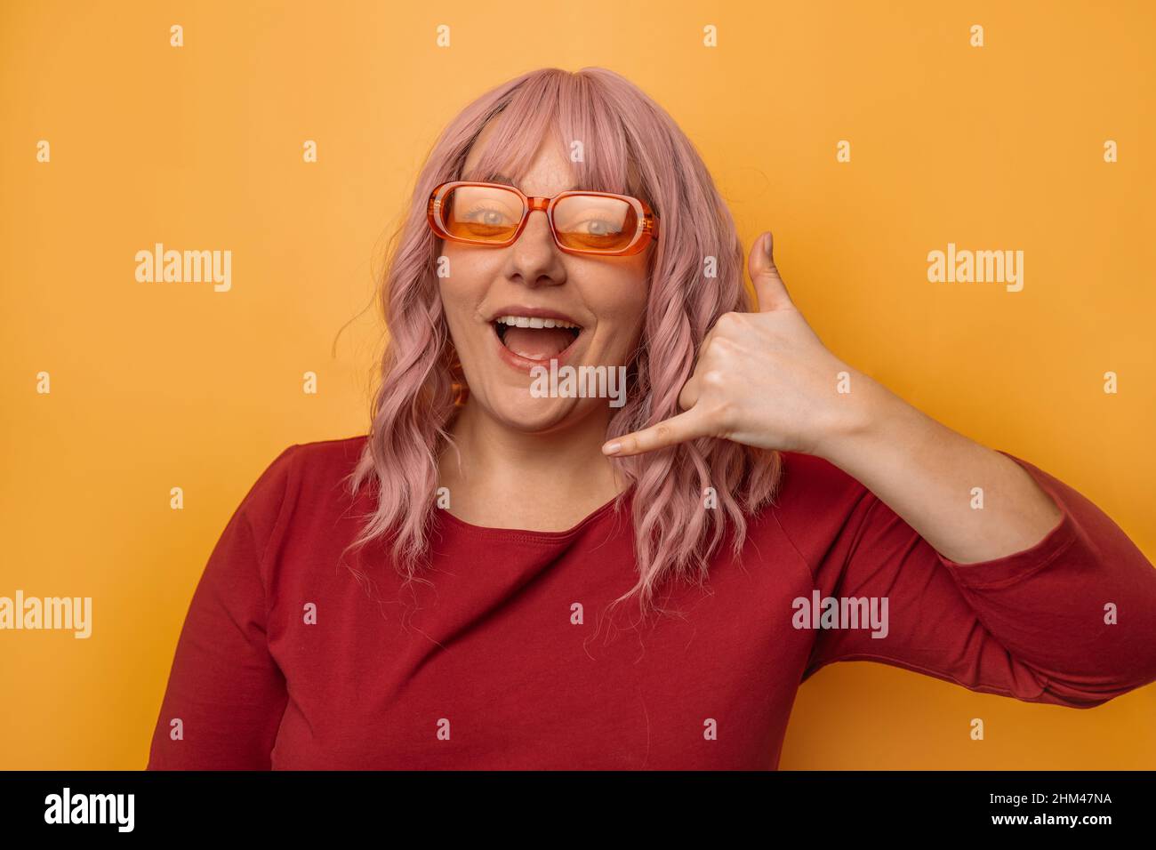 Beautiful smiling girl showing call me, smiling camera have fun shows ...