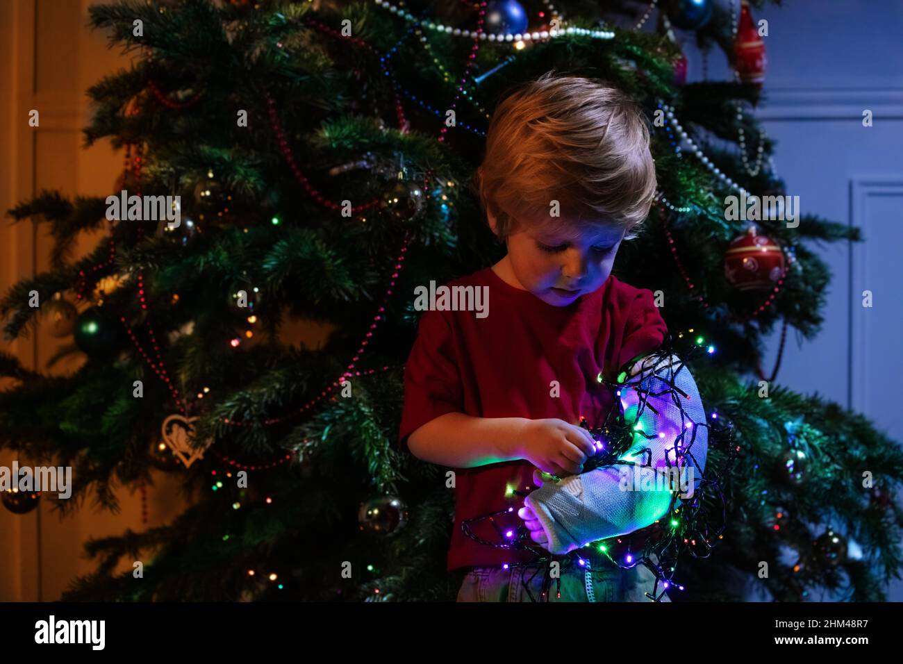 Toddler broken hand in cast illuminated by garland Stock Photo - Alamy