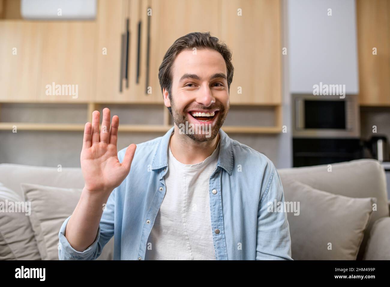 Glad to meet you. Screensaver with handsome guy in casual wear waving ...